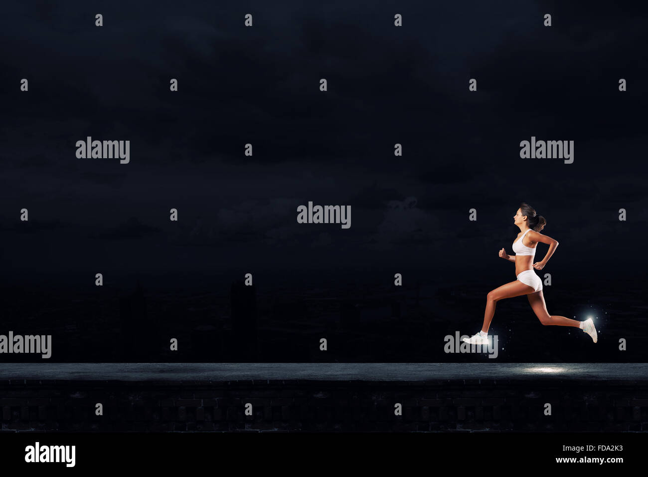 Young woman athlete running fast on dark background Stock Photo - Alamy