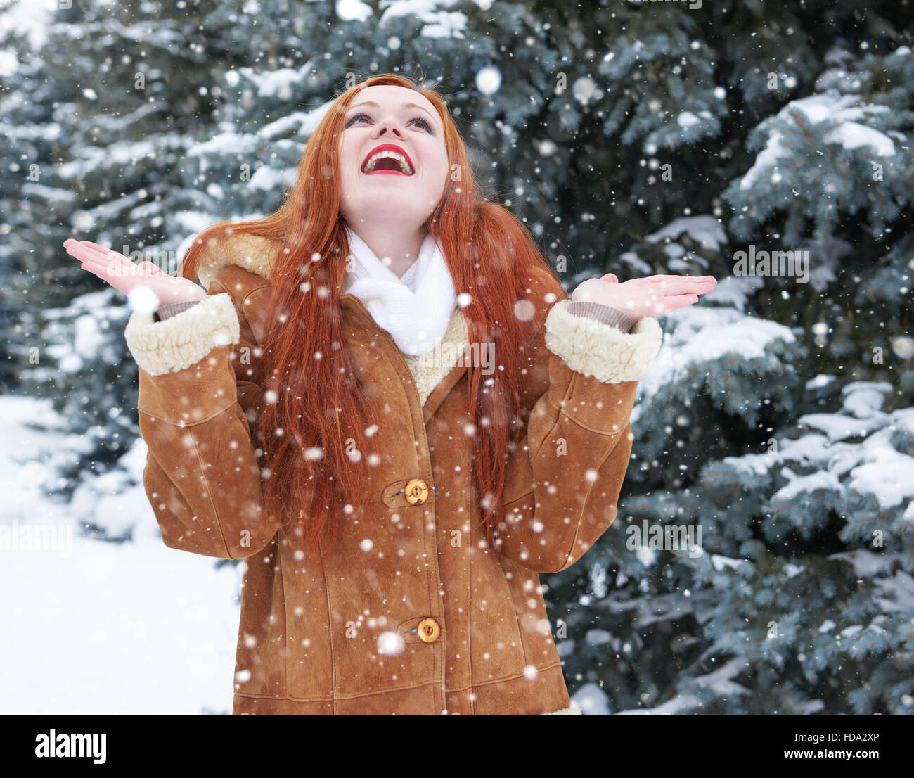 Winter woman joy, looking up on snow, outdoor portrait, snowy fir trees ...
