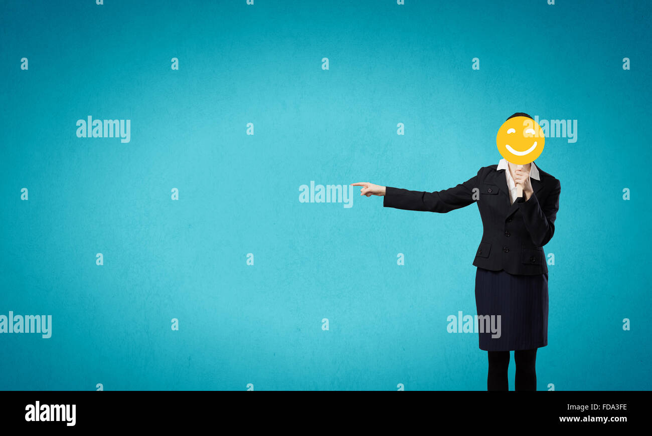 Unrecognizable businesswoman hiding her face behind mask and showing ...