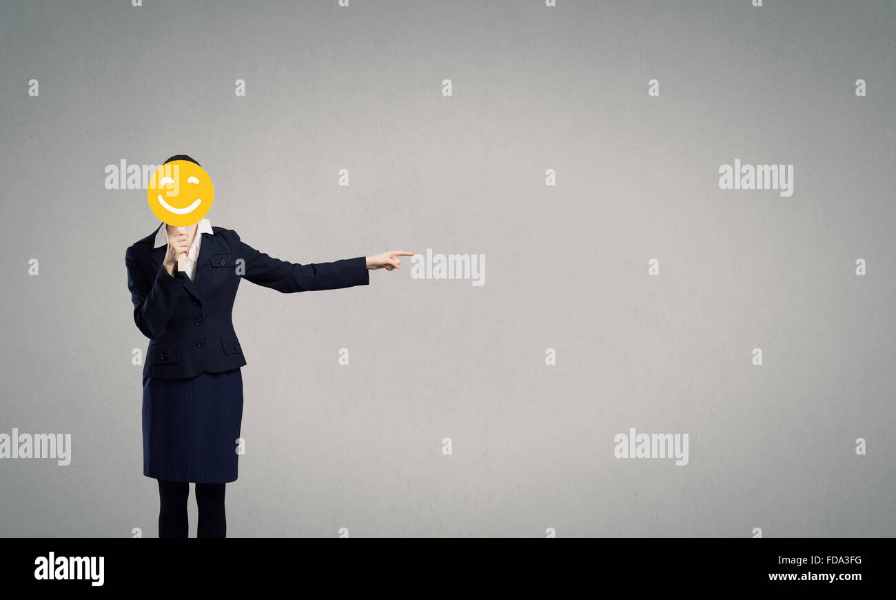 Unrecognizable businesswoman hiding her face behind mask and showing ...