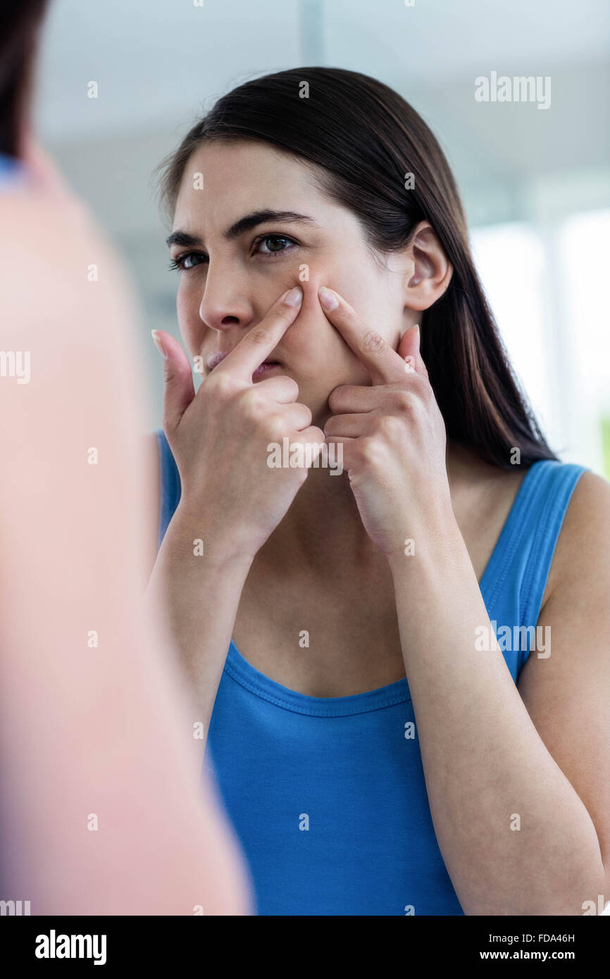 Unhappy woman with skin irritation cleaning her face Stock Photo - Alamy