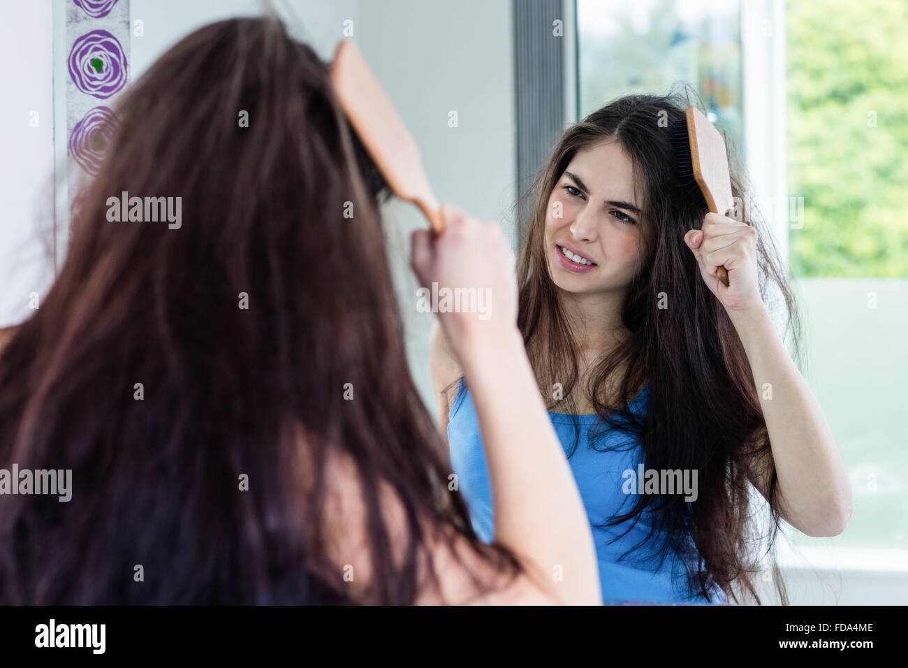 Unsmiling brunette combing Stock Photo - Alamy