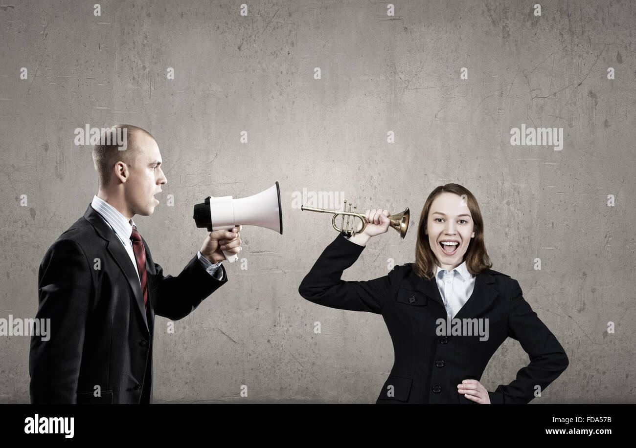 Businessman using megaphone to scream agressively at woman Stock Photo ...