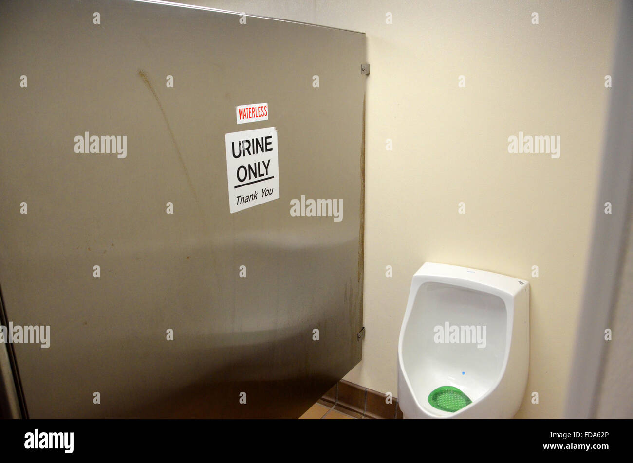 urinal with urine only sign waterless sticker Stock Photo - Alamy