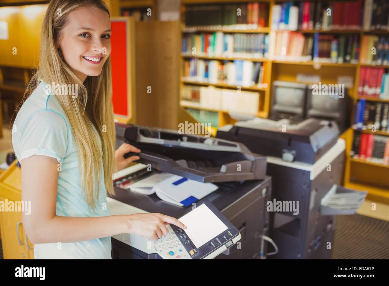 Smiling blonde student making a copy Stock Photo - Alamy