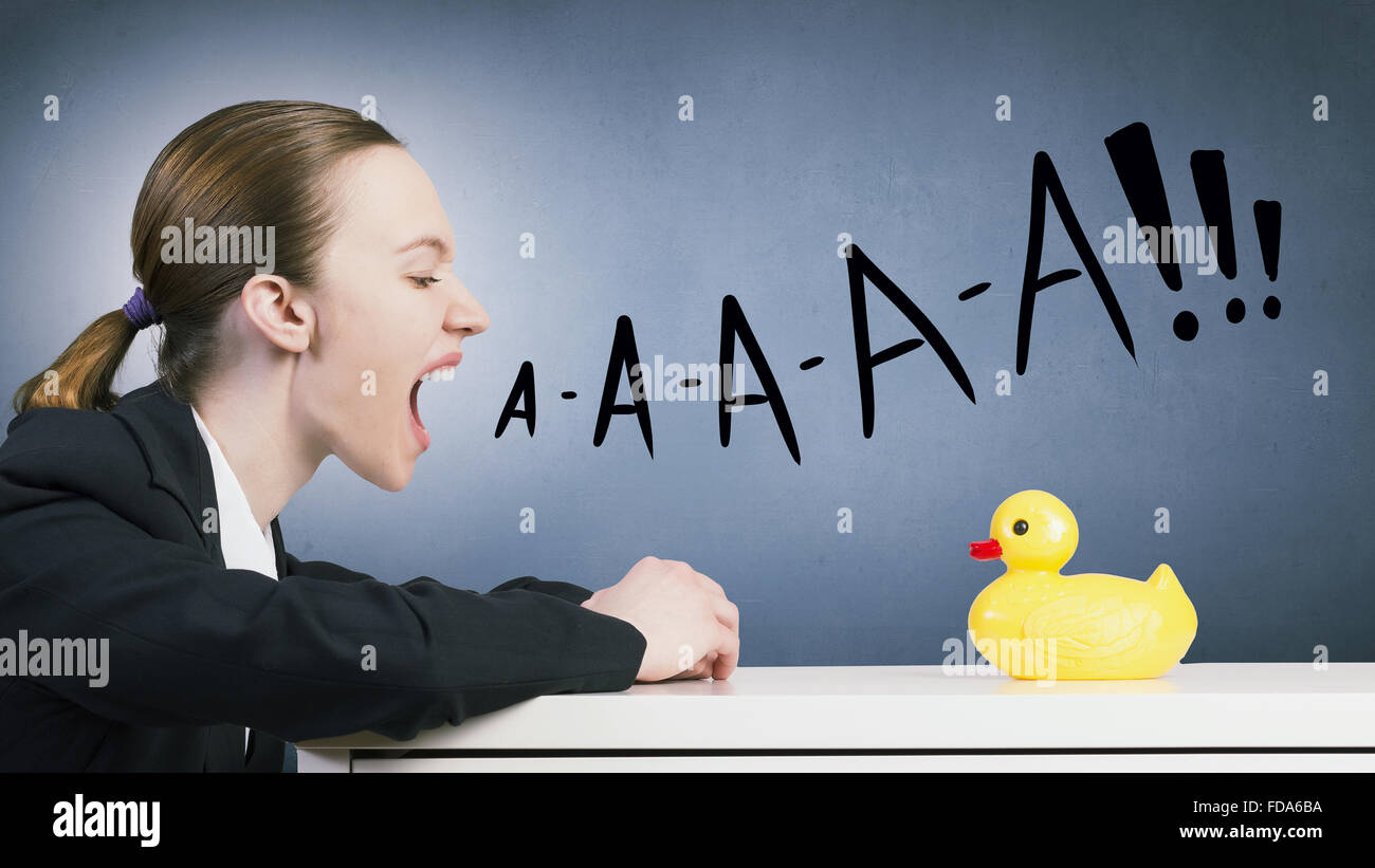 Young businesswoman screaming on yellow rubber duck toy Stock Photo - Alamy