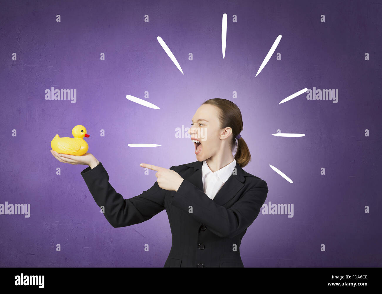 Young businesswoman screaming and pointing on yellow rubber duck toy ...
