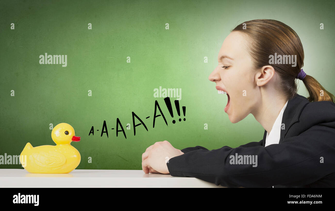 Young businesswoman screaming on yellow rubber duck toy Stock Photo - Alamy