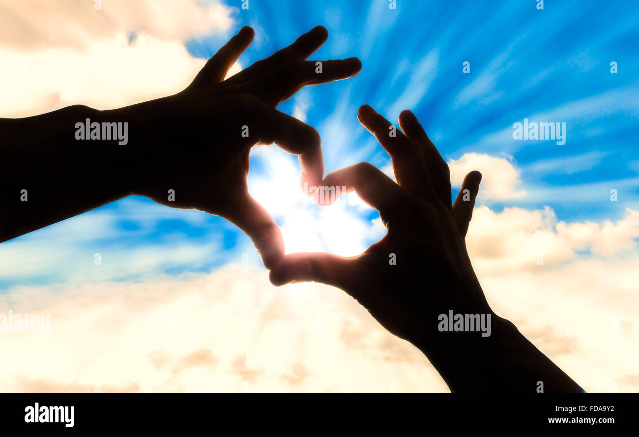 Silhouette hands in heart shape and blue sky Stock Photo - Alamy