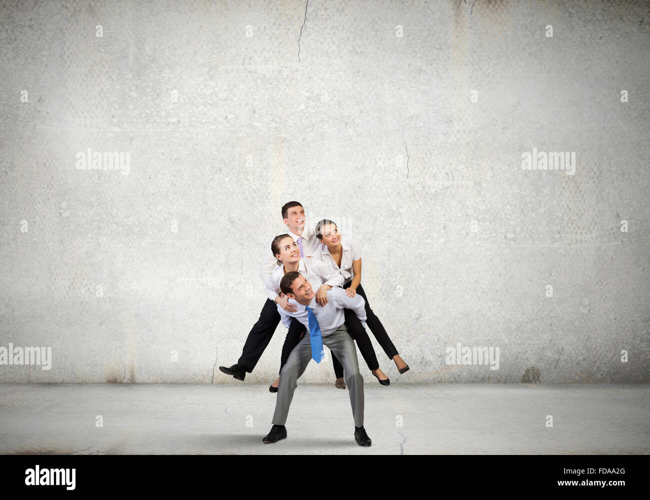 Businesspeople riding on back of their colleague Stock Photo - Alamy