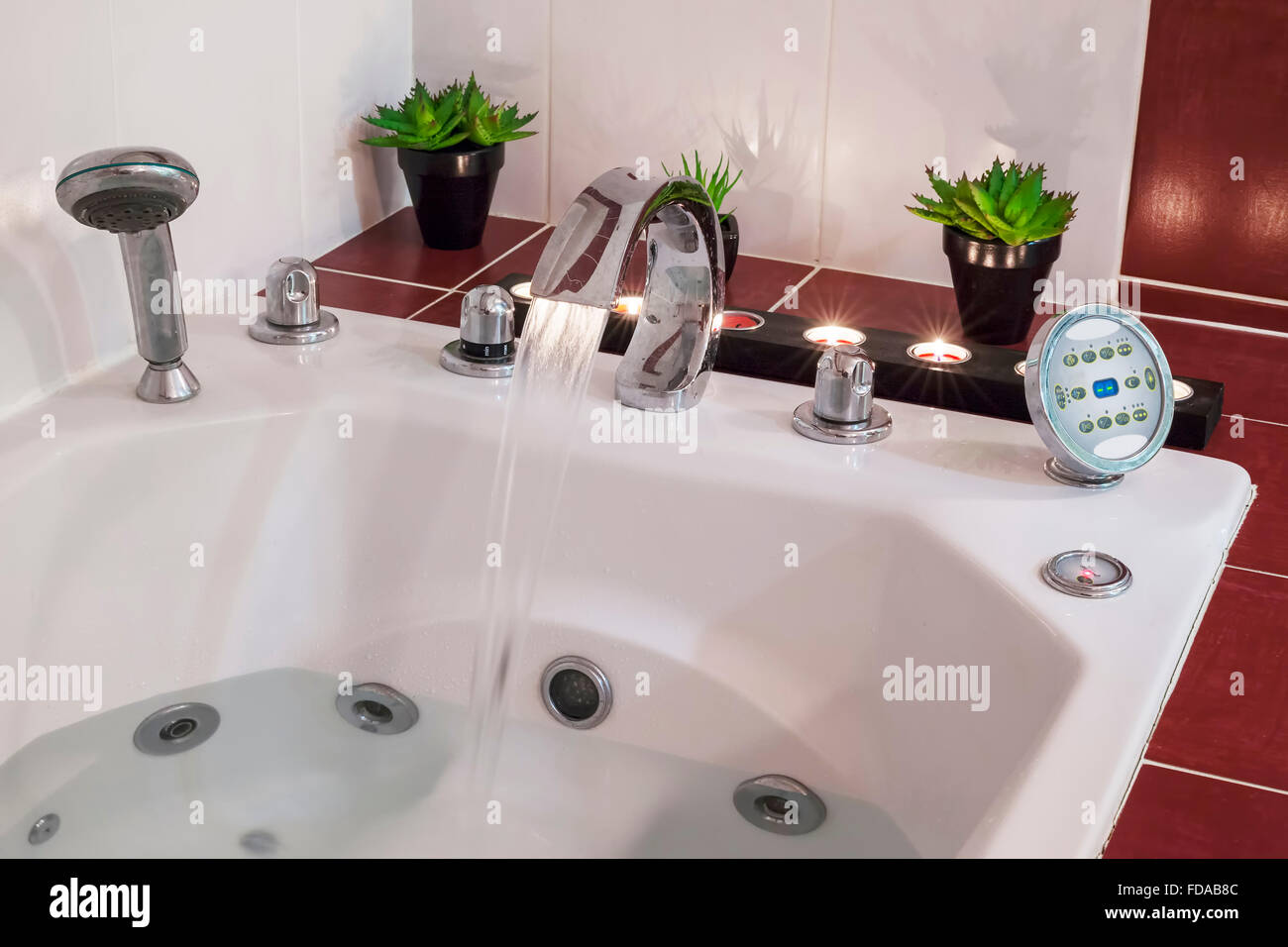 Jacuzzi bath with water, candles and plants Stock Photo - Alamy