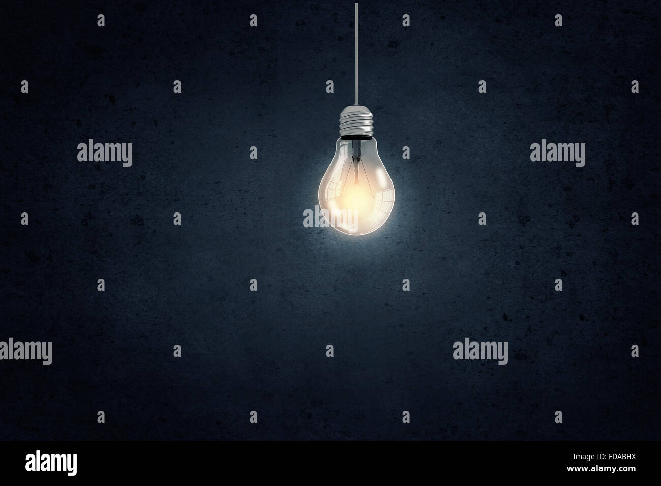 Glowing light bulb on dark background hanging from above Stock Photo ...