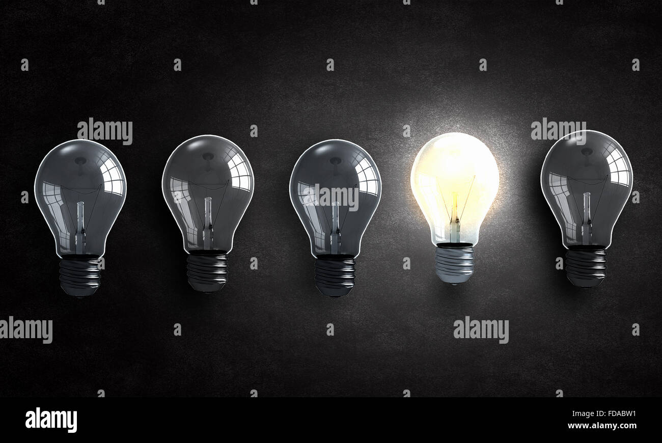Light bulbs on dark background with one glowing Stock Photo - Alamy