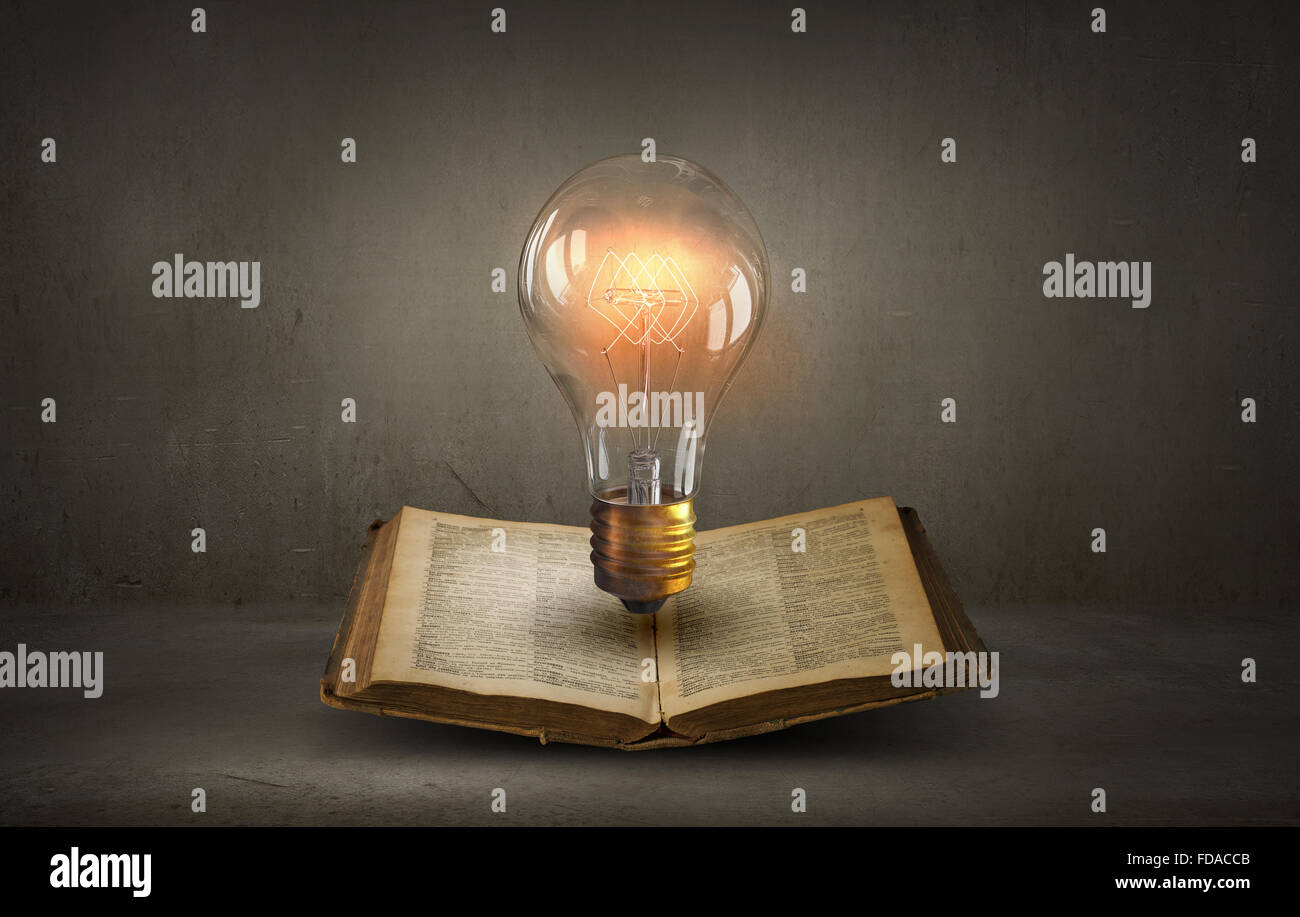 Glass glowing light bulb on opened book Stock Photo - Alamy