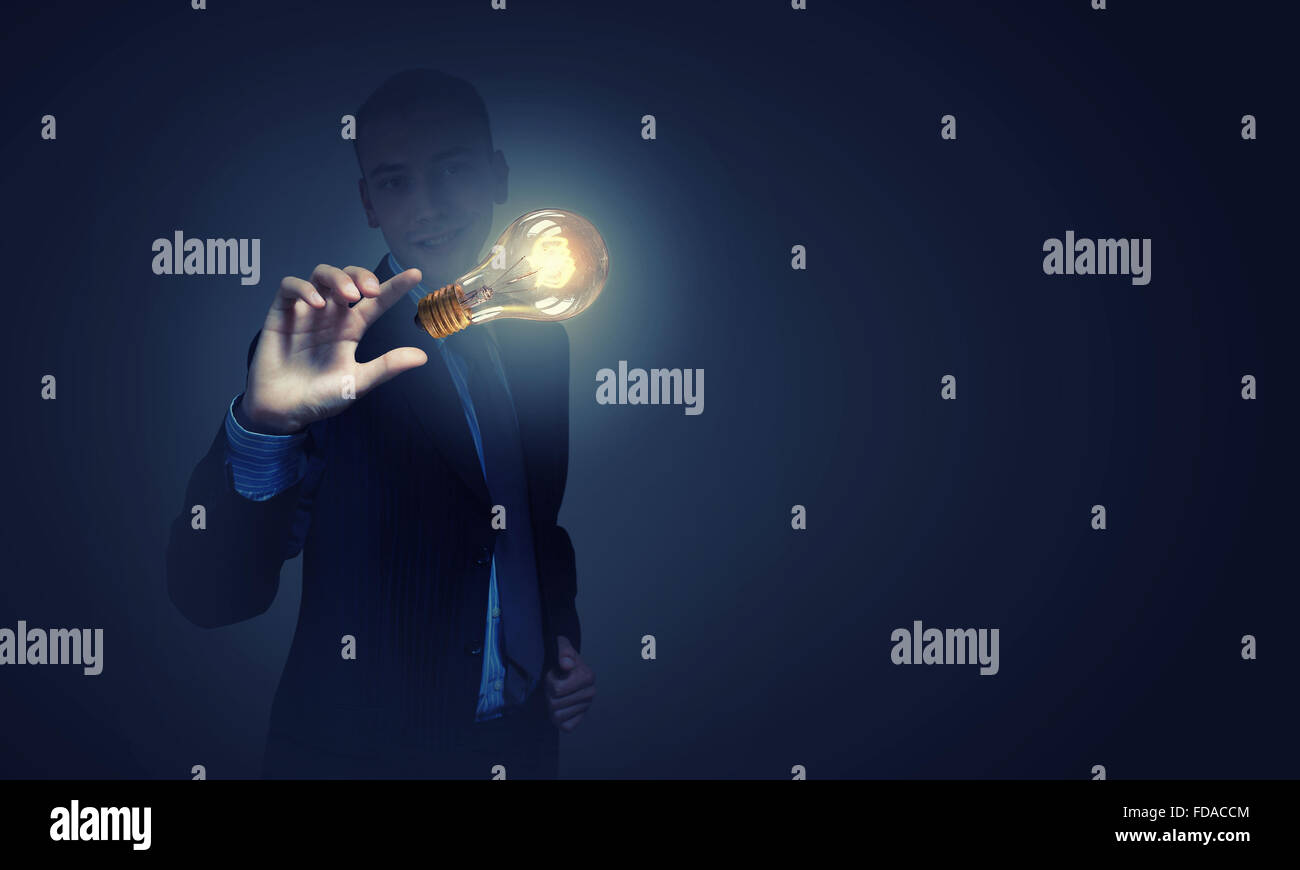 Young businessman catching glass light bulb with finger Stock Photo - Alamy