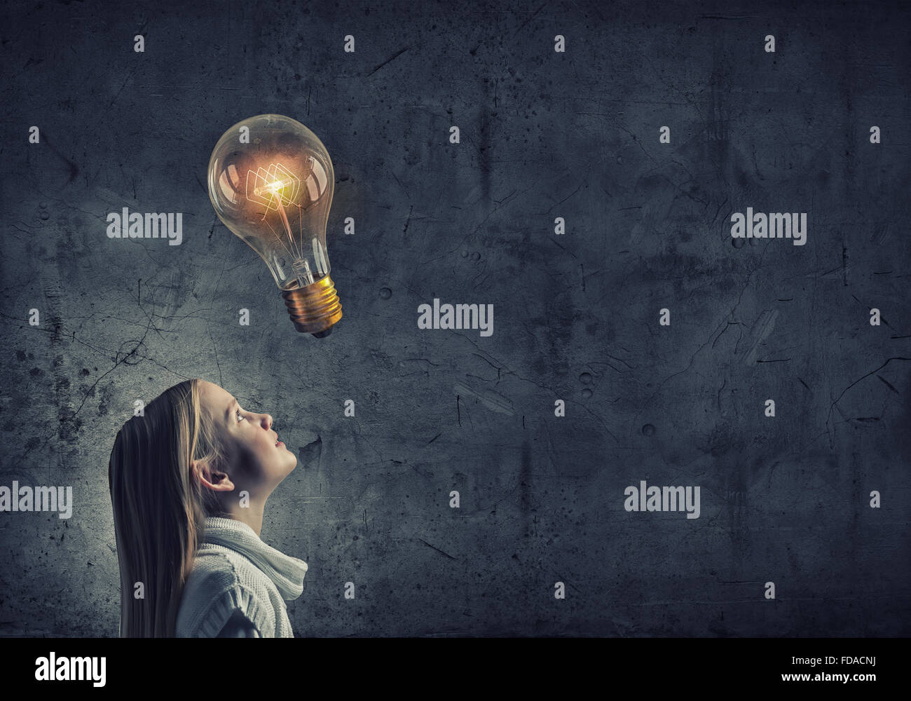 Girl of school age looking above at light bulb Stock Photo - Alamy