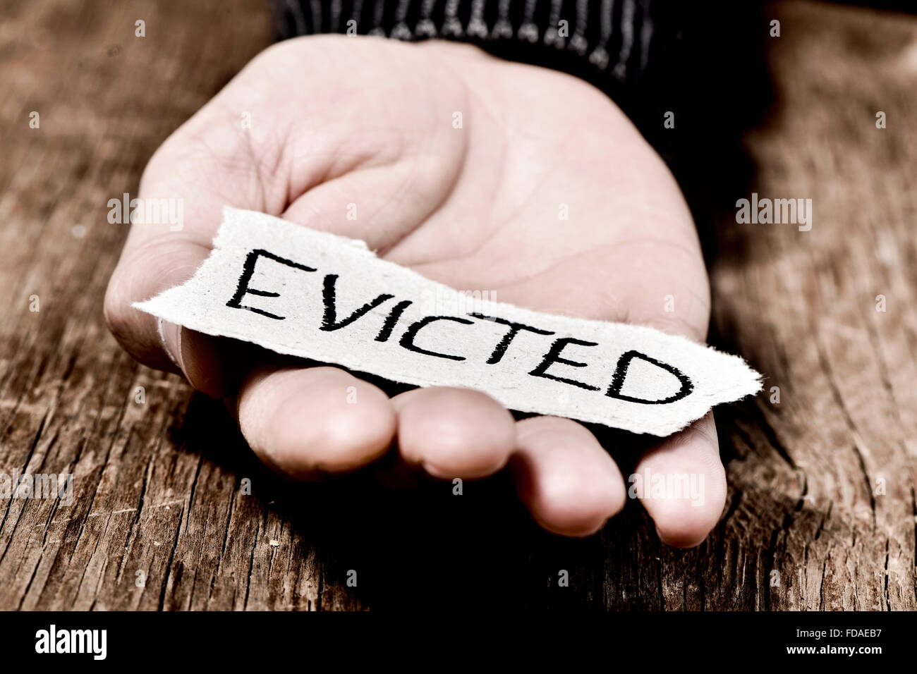 closeup of a piece of paper with the word evicted in the hand of a ...