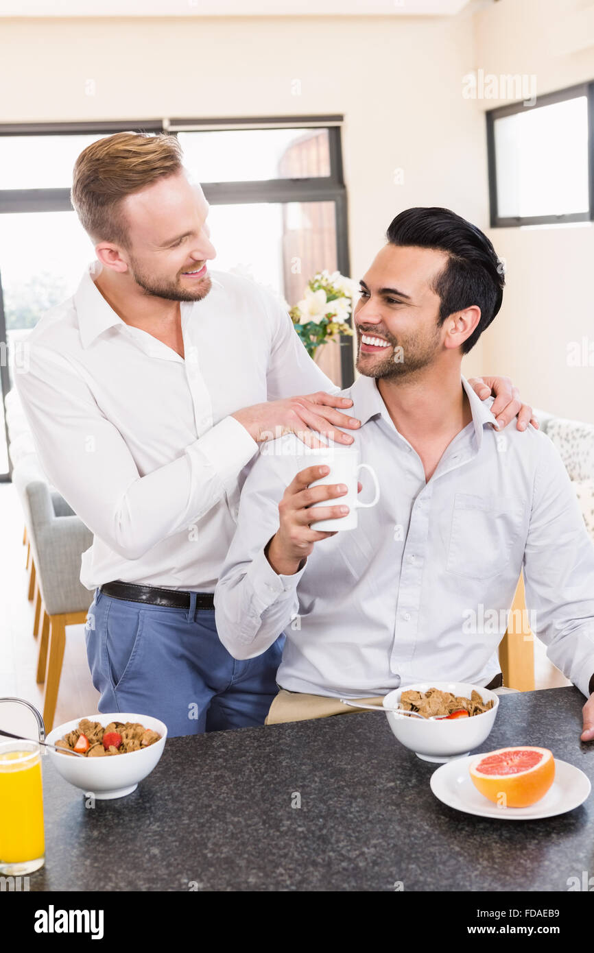 Smiling gay couple having breakfast Stock Photo - Alamy