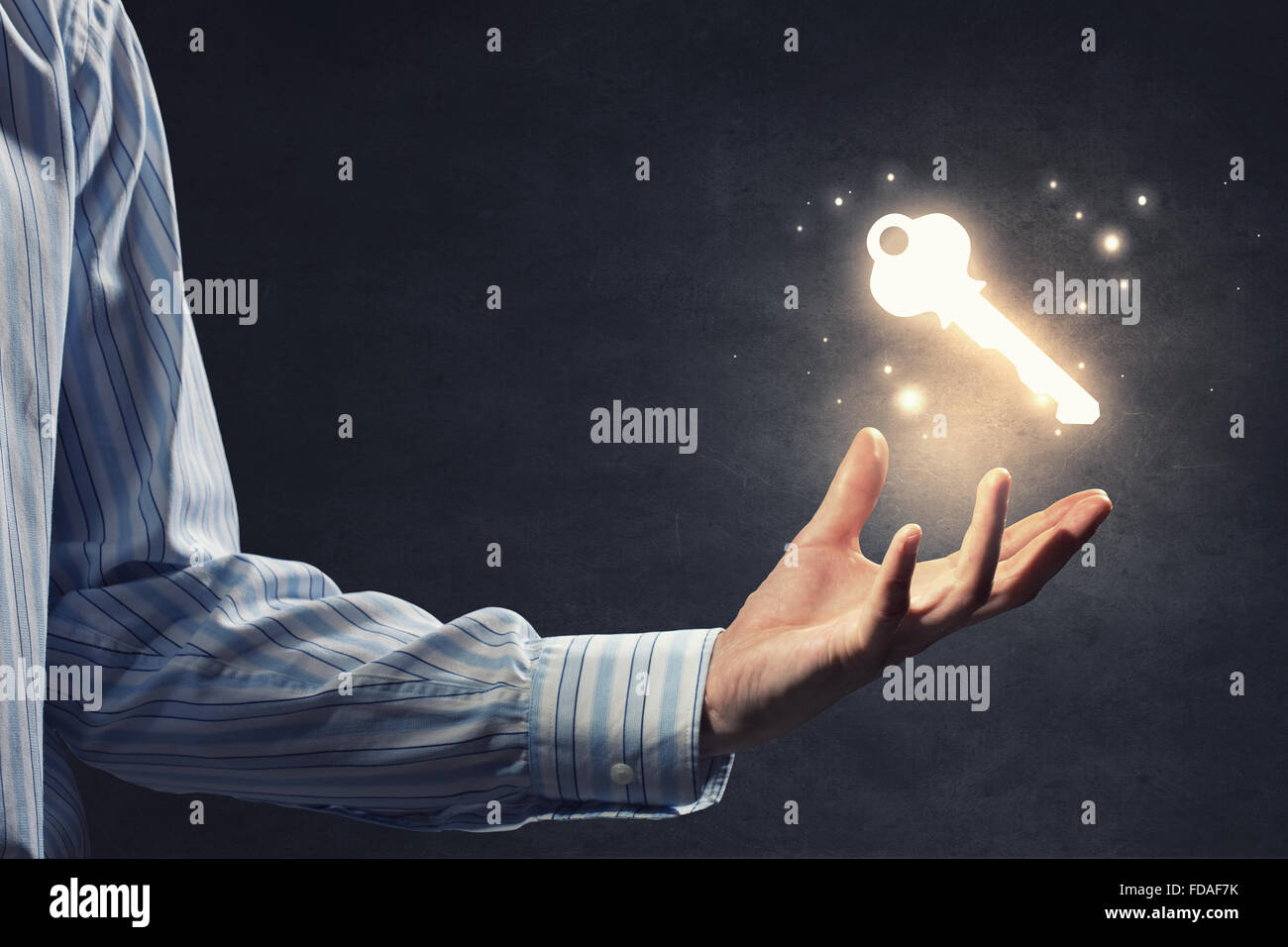 Close up of human hand holding key symbol Stock Photo - Alamy