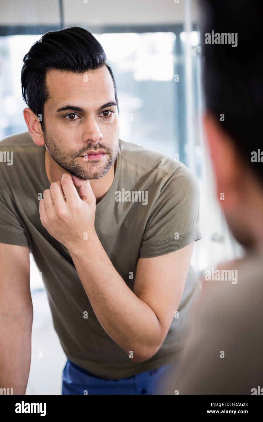 Handsome man looking in mirror Stock Photo - Alamy