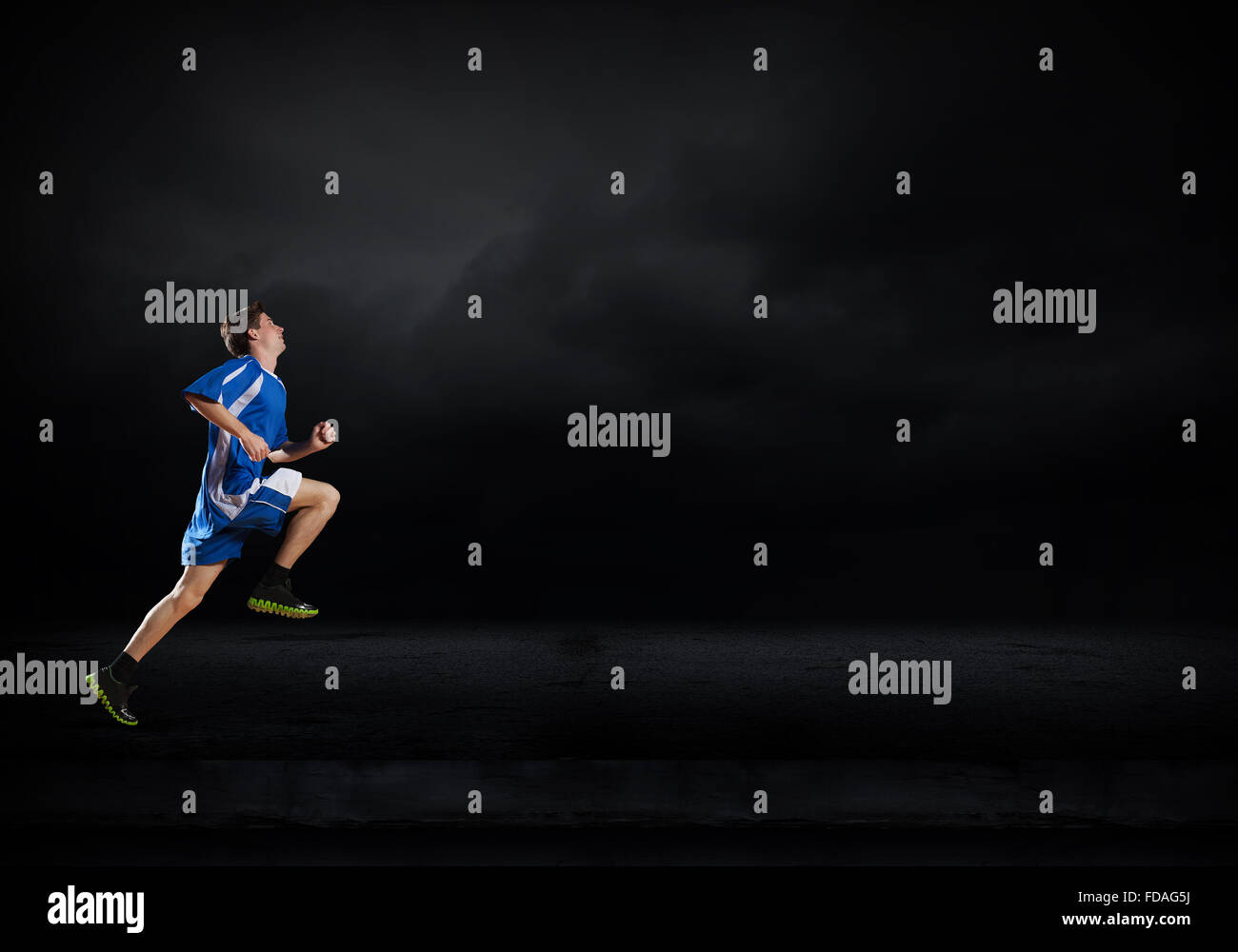 Running man in blue sport wear on black background Stock Photo - Alamy
