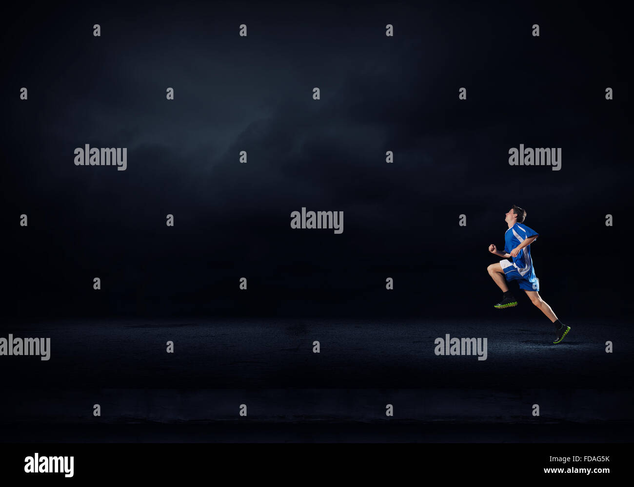 Running man in blue sport wear on black background Stock Photo - Alamy
