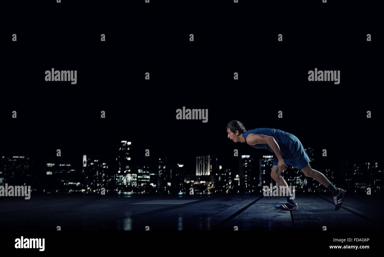 Running man in blue sport wear on black background Stock Photo - Alamy