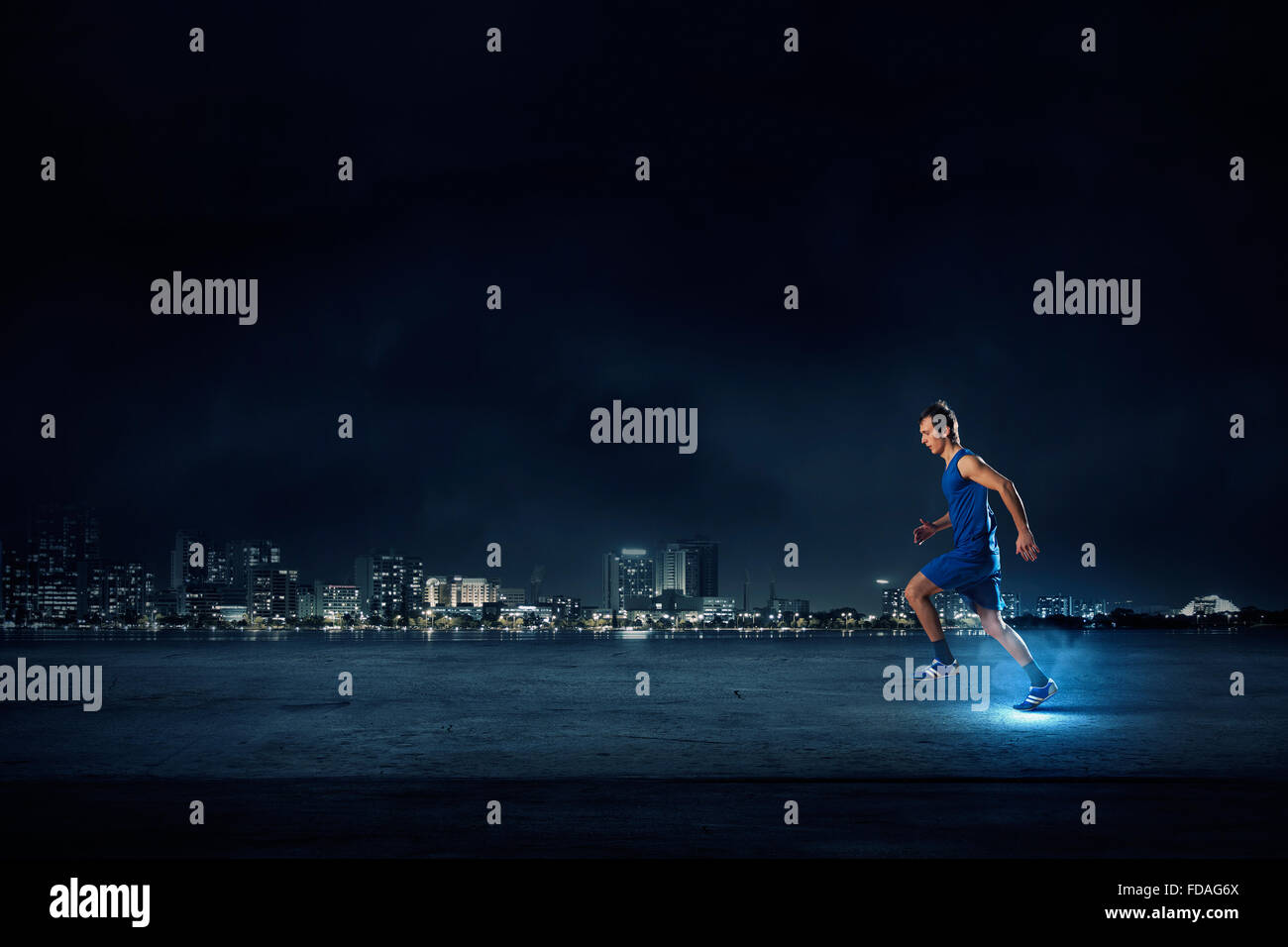 Running man in blue sport wear on black background Stock Photo - Alamy