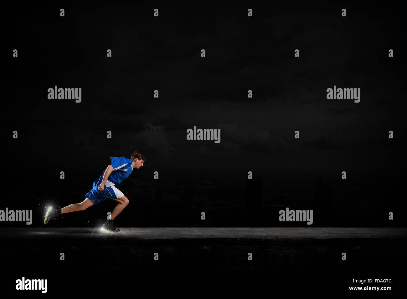 Running man in blue sport wear on black background Stock Photo - Alamy