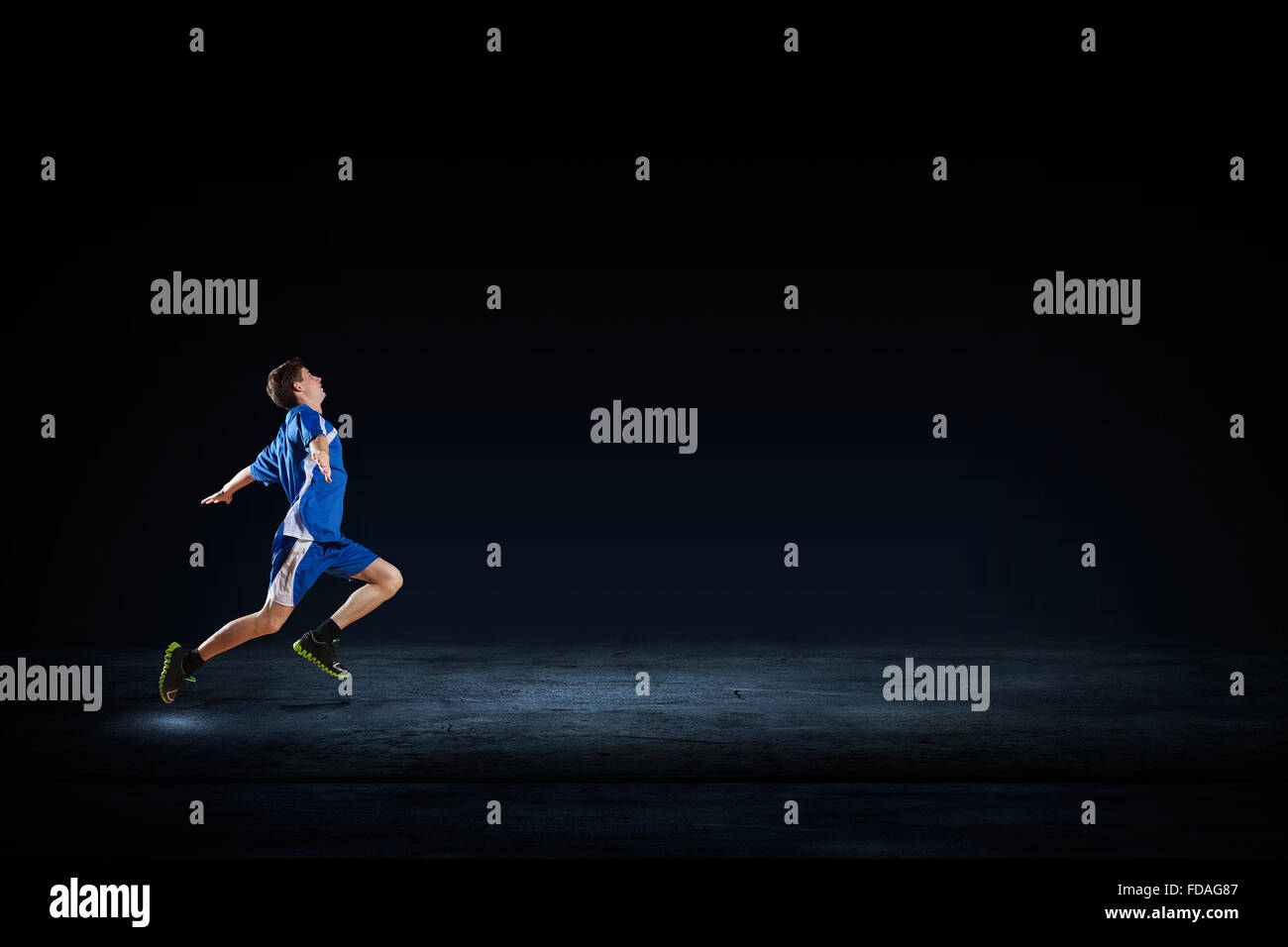 Running man in blue sport wear on black background Stock Photo - Alamy