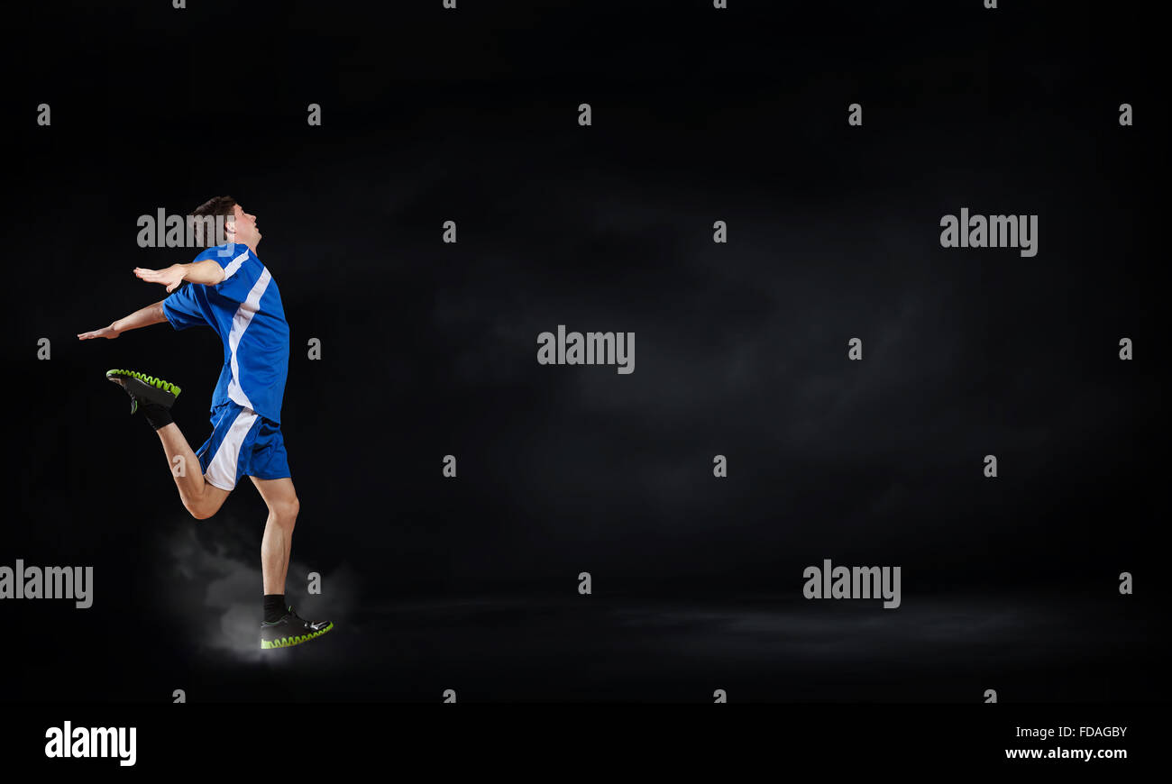 Running man in blue sport wear on black background Stock Photo - Alamy