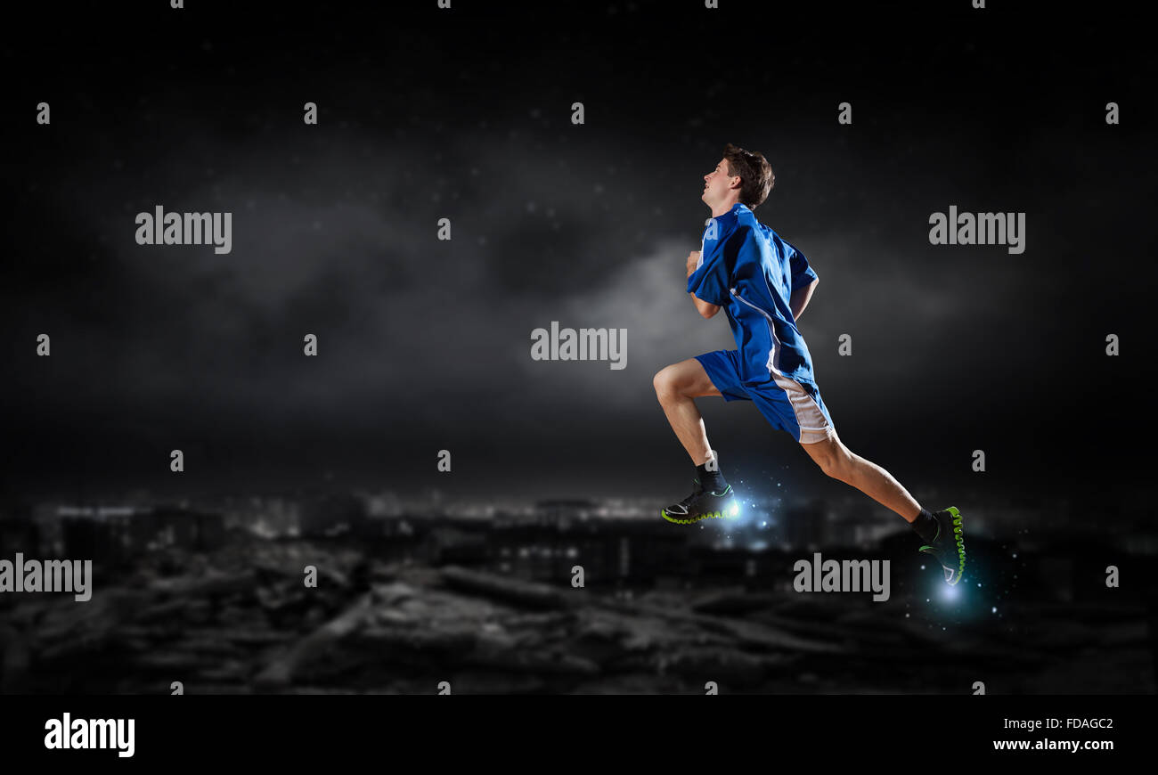 Running man in blue sport wear on black background Stock Photo - Alamy