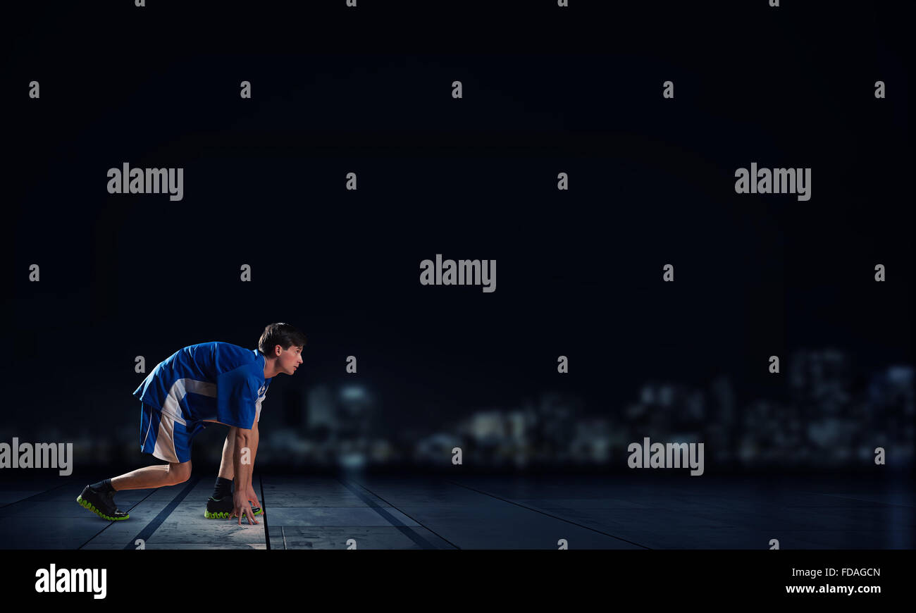 Athlete man in start pose on black background Stock Photo - Alamy
