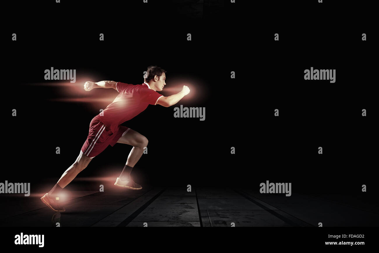 Running man in red sport wear on dark background Stock Photo - Alamy