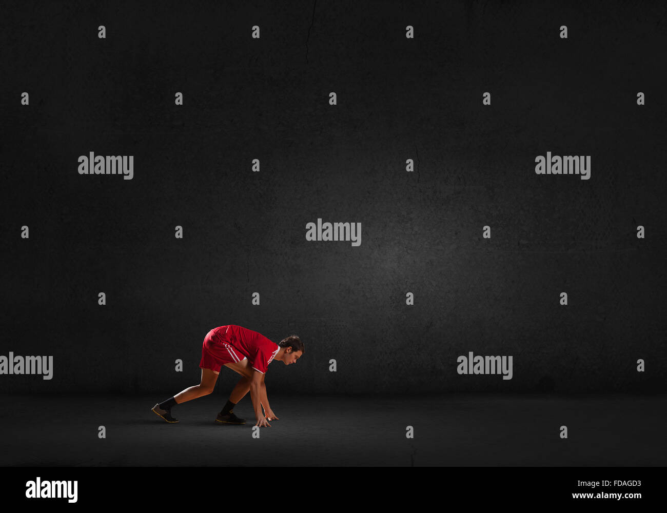 Running man in red sport wear on dark background Stock Photo - Alamy