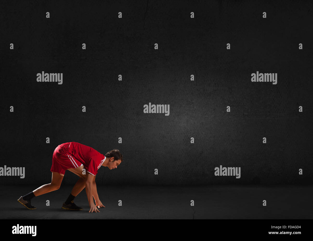Running man in red sport wear on dark background Stock Photo - Alamy