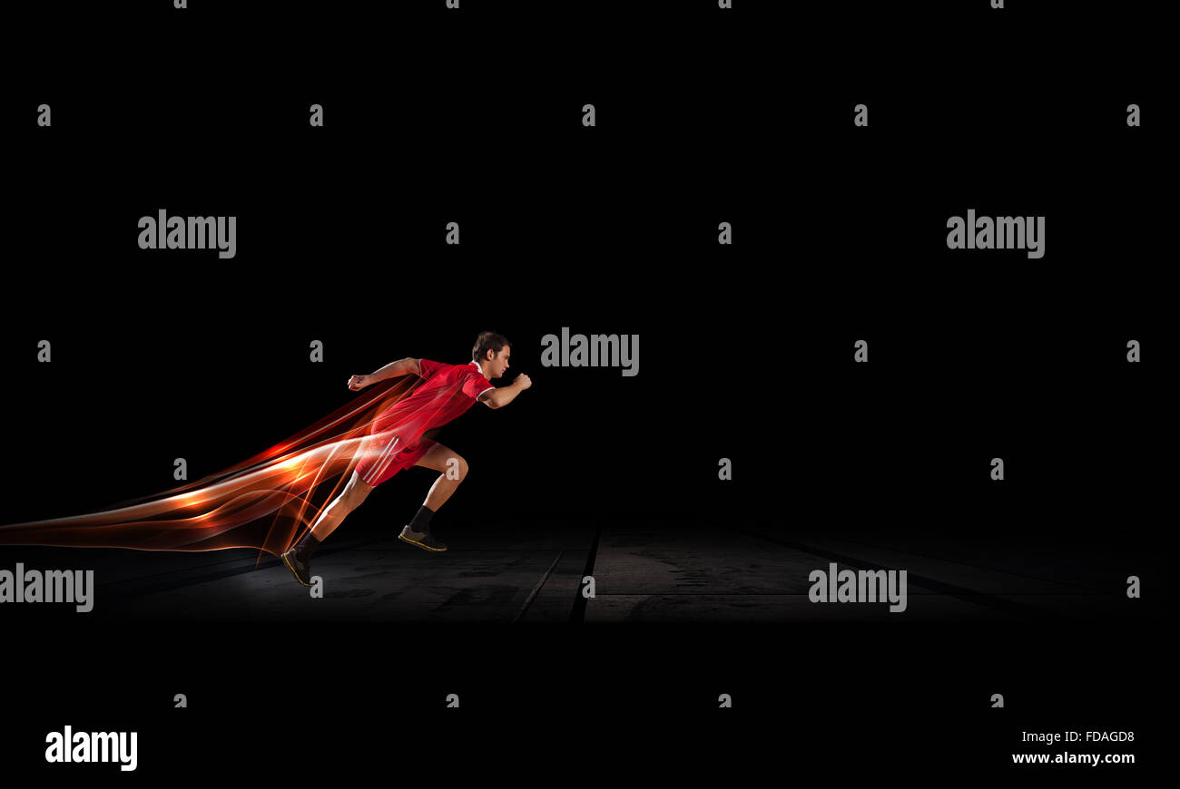 Running man in red sport wear on dark background Stock Photo - Alamy