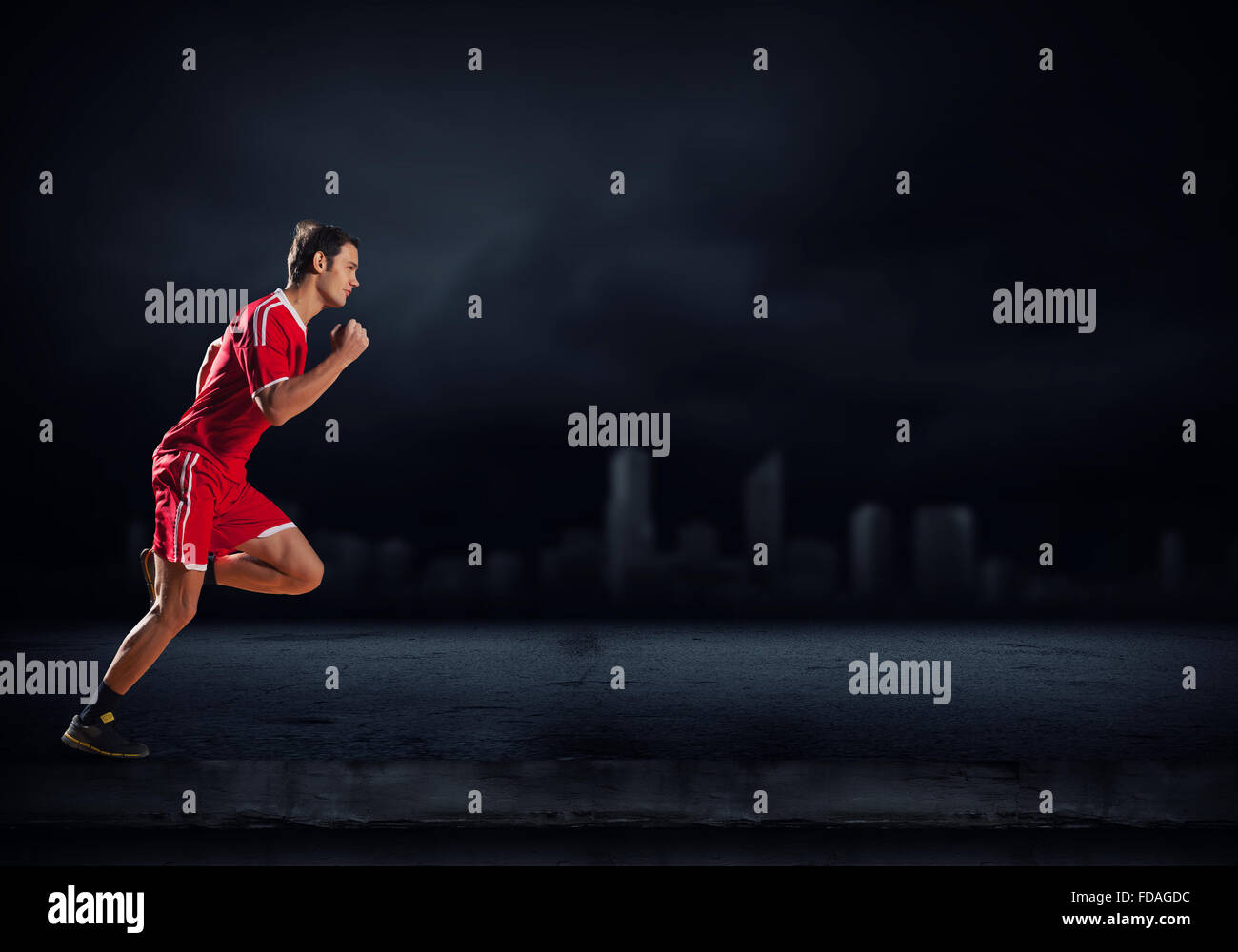 Running man in red sport wear on dark background Stock Photo - Alamy