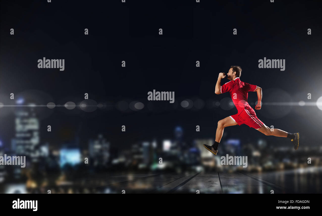 Running man in red sport wear on dark background Stock Photo - Alamy