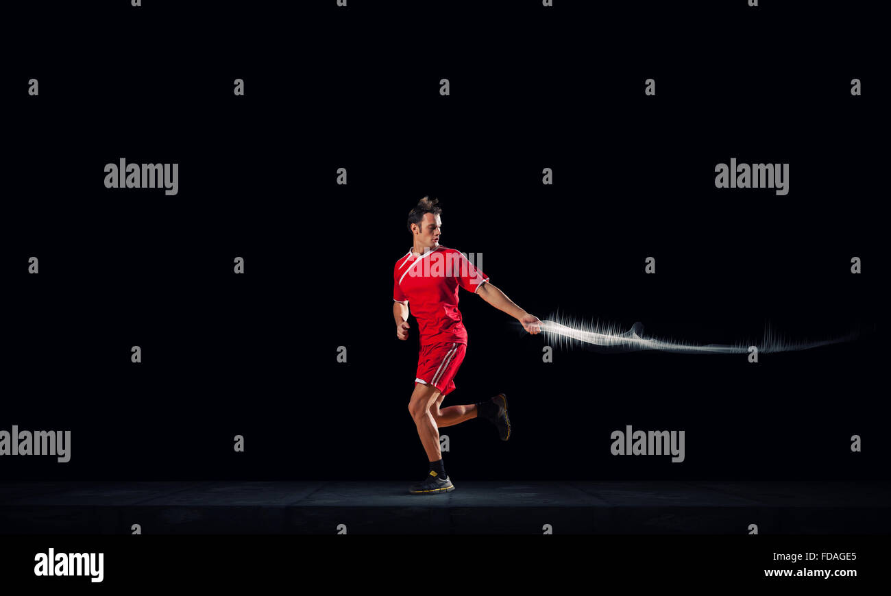 Running man in red sport wear on dark background Stock Photo - Alamy