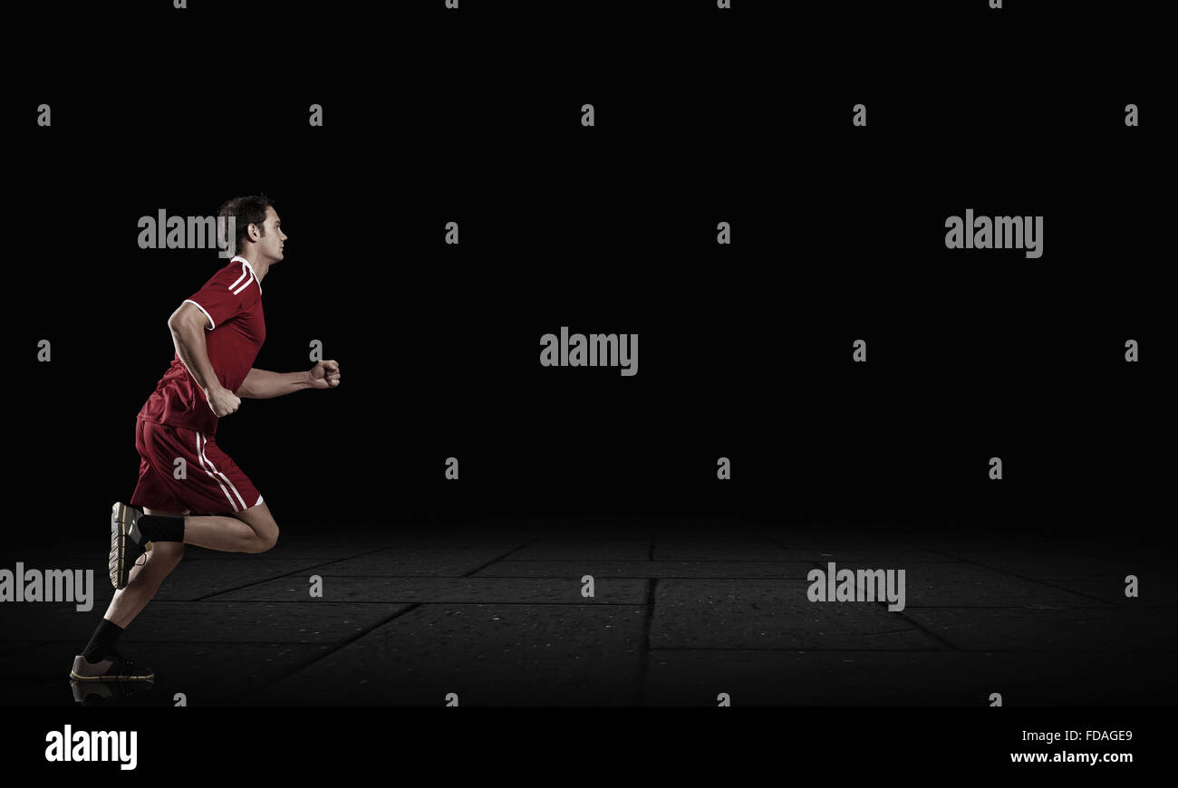 Running man in red sport wear on dark background Stock Photo - Alamy