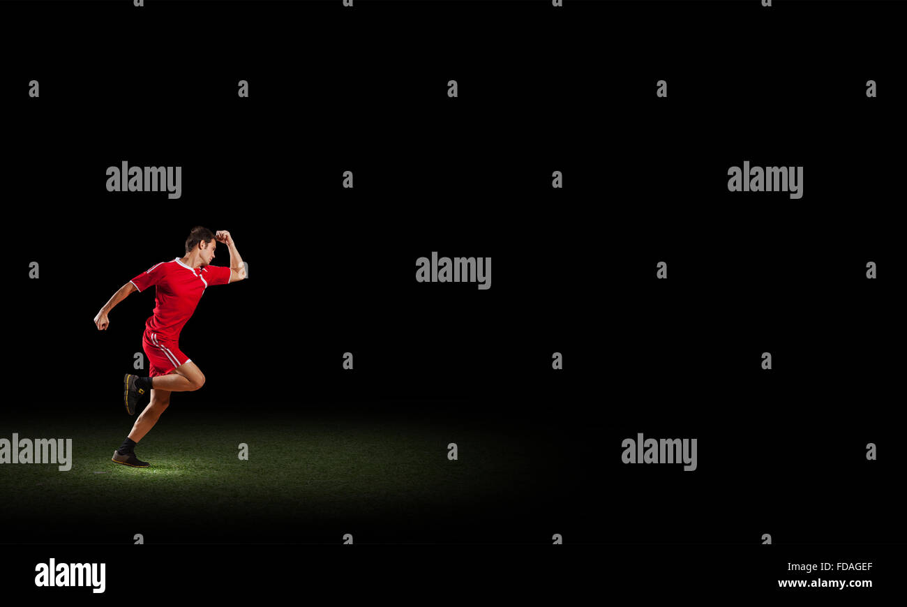 Running man in red sport wear on dark background Stock Photo - Alamy