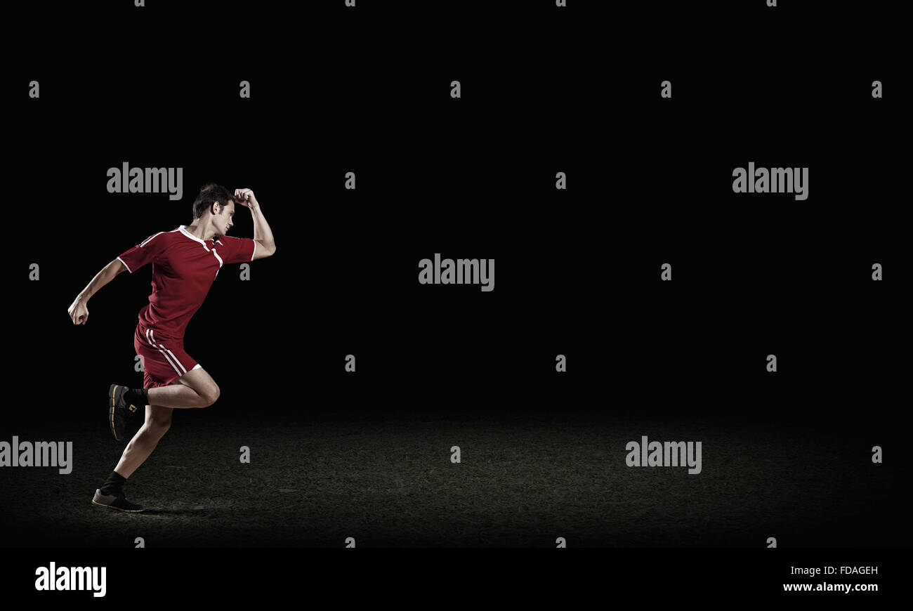 Running man in red sport wear on dark background Stock Photo - Alamy