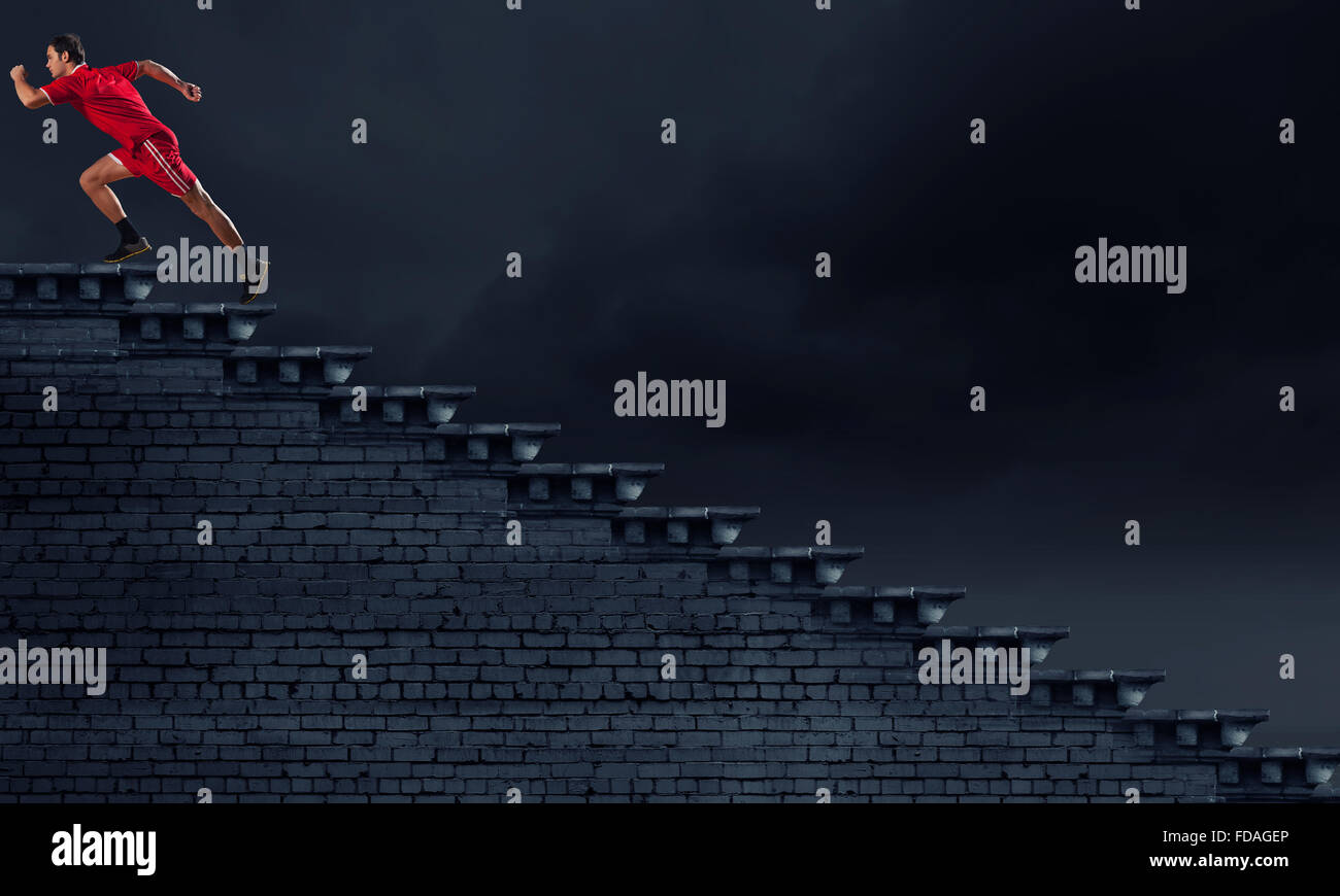Athlete man in red sport wear running up staircase Stock Photo - Alamy