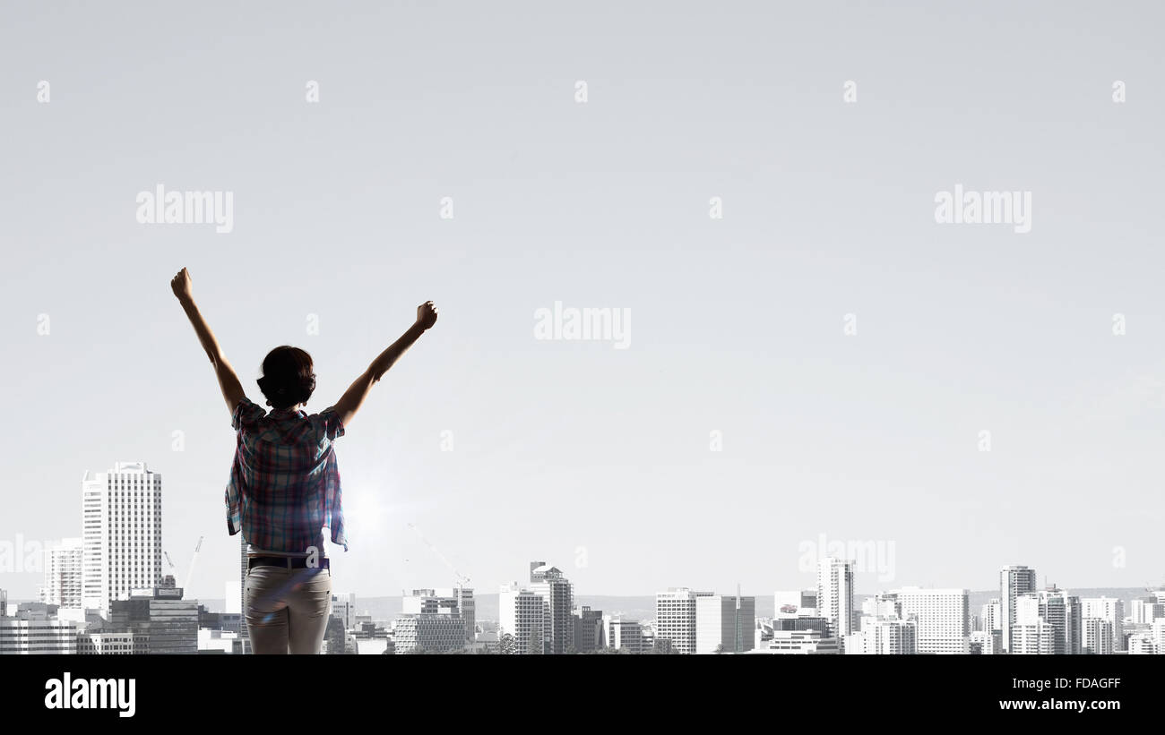 Back view of cheerful woman with hands up facing sunrise Stock Photo ...