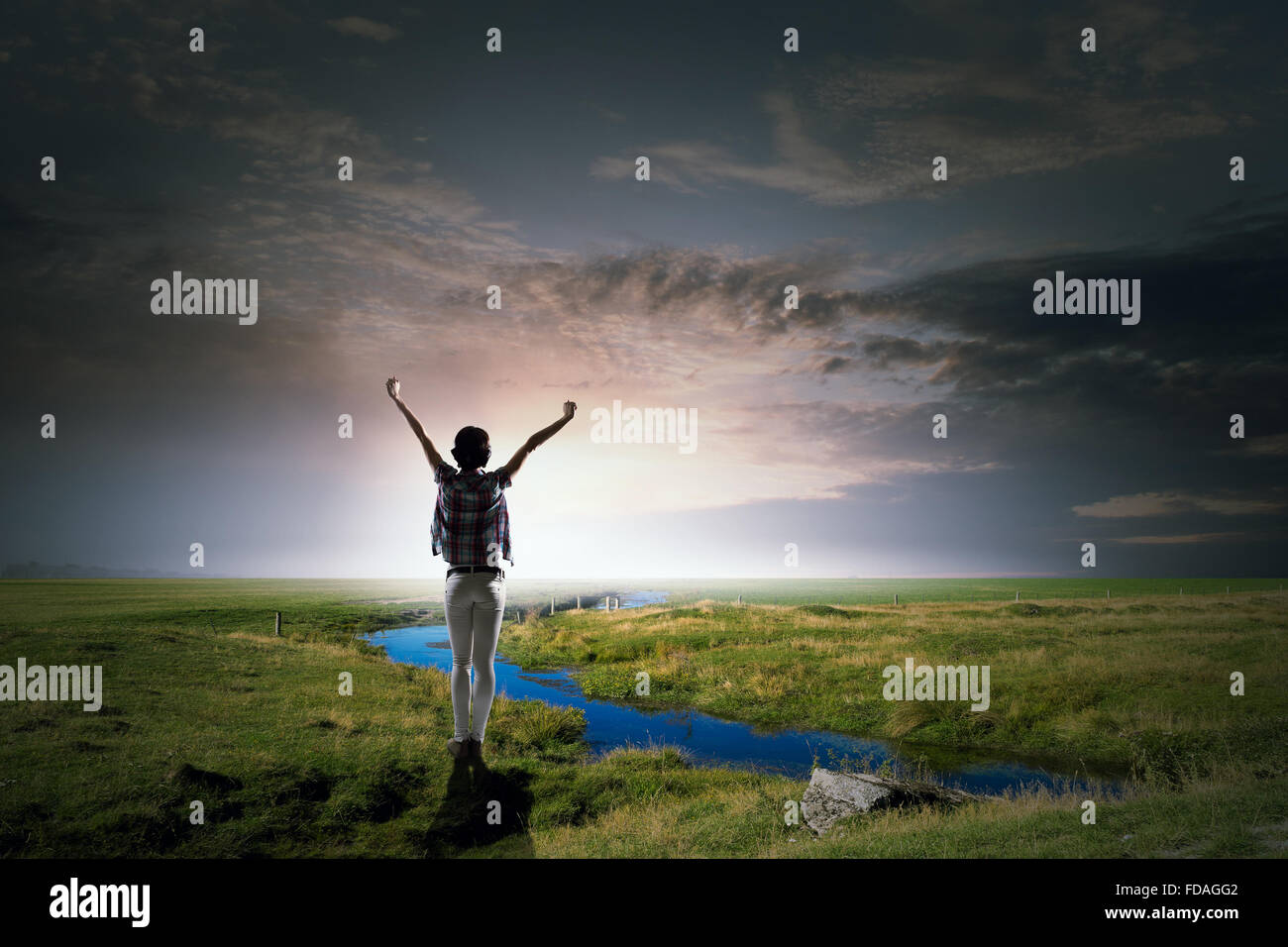 Back view of cheerful woman with hands up facing sunrise Stock Photo ...