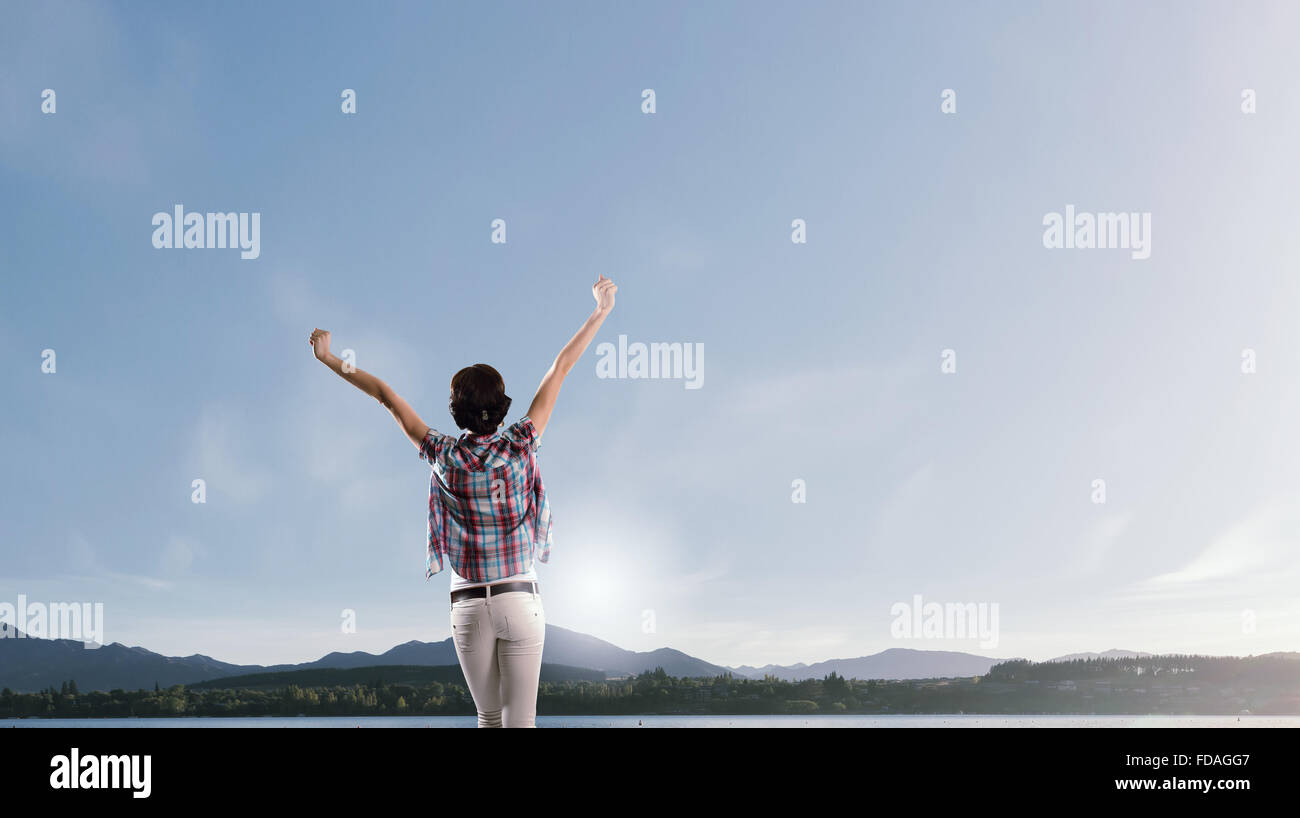 Back view of cheerful woman with hands up facing sunrise Stock Photo ...