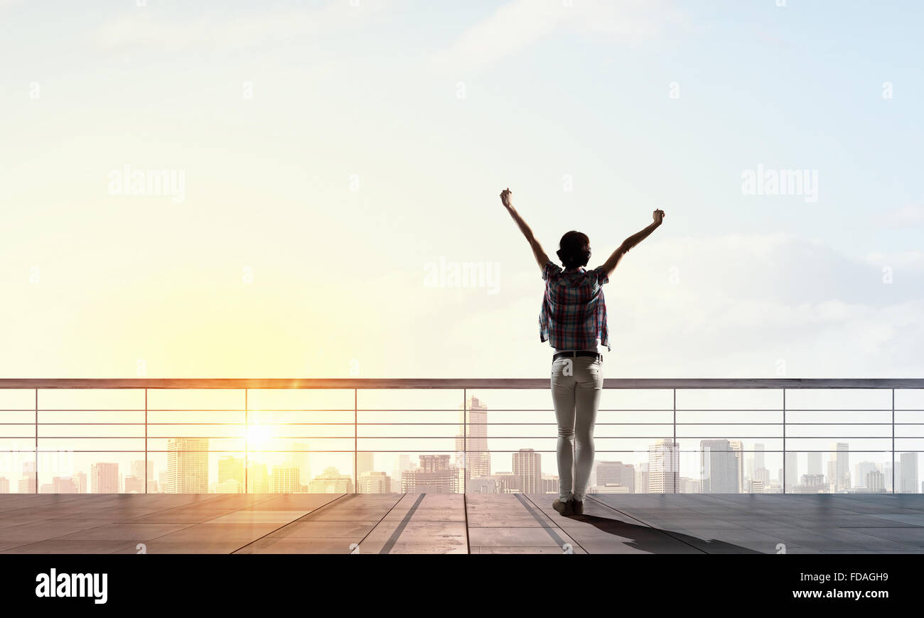 Back view of cheerful woman with hands up facing sunrise Stock Photo ...