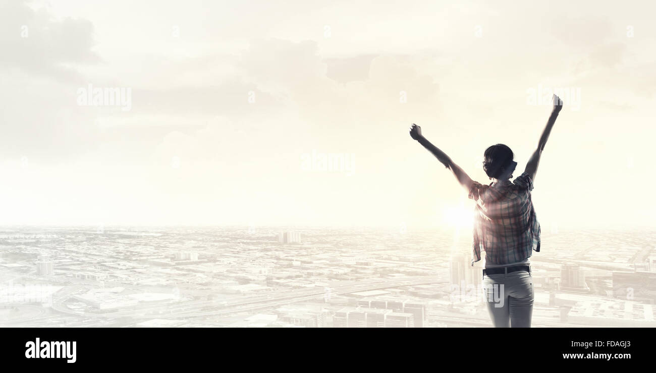 Back view of cheerful woman with hands up facing sunrise Stock Photo ...