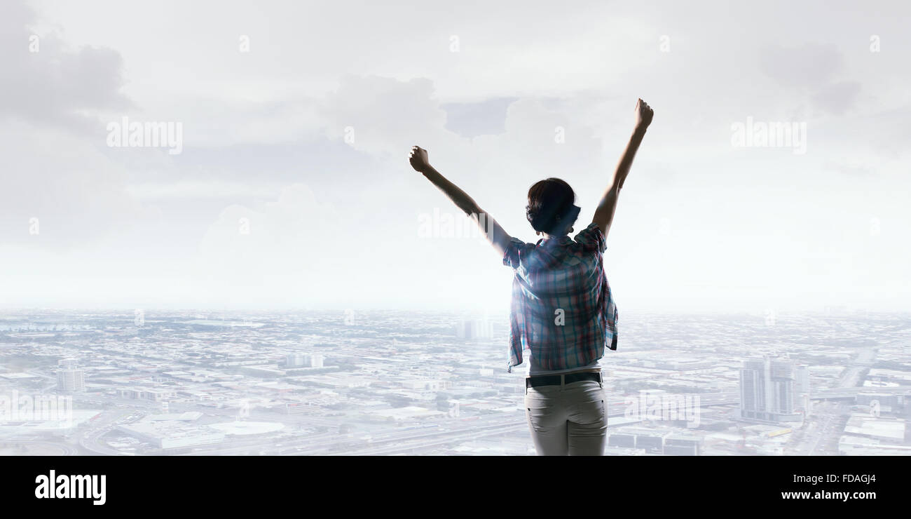 Back view of cheerful woman with hands up facing sunrise Stock Photo ...